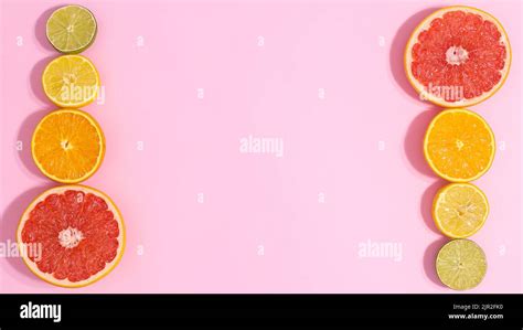 Pastel Pink Background With Sliced Citrus Fruits On Right And Left Side
