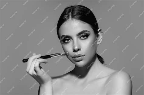 Premium Photo Woman Applying Foundation Powder Or Blush With Makeup