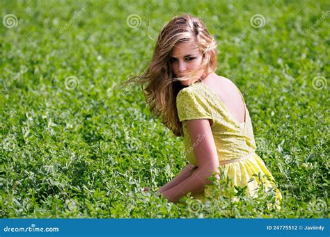 Härlig Blond Flicka Som Sitter I En äng Arkivfoto Bild Av Livsstilar