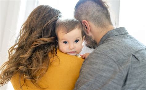 Madre Y Padre Parados En Su Sala De Estar Con Su Bebé Imagen De Archivo
