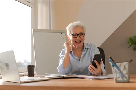 Premium Photo Confident Middle Aged Senior Woman Euphoric Winner With Smartphone Older Mature