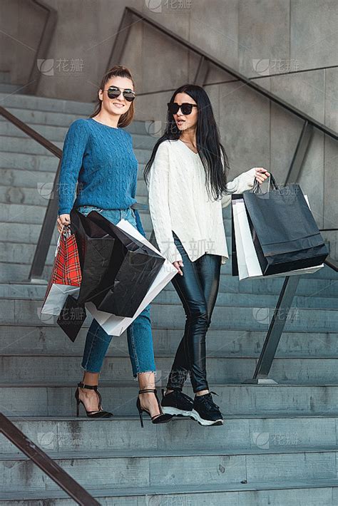 商场外的漂亮女孩拿着纸袋