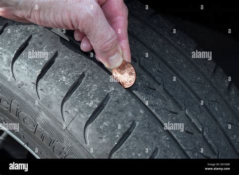 Checking The Tread Depth On Car Tyre Using A Coin Stock Photo Alamy