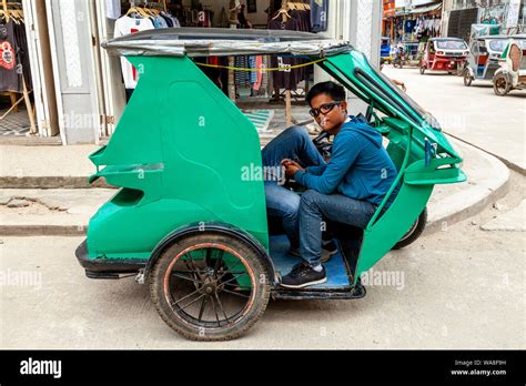 Two Men Sitting Inside A Motorcycle Tricycle Taxi Waiting For