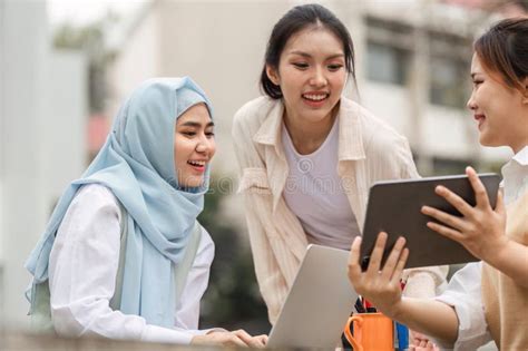 Diverse Women Collaborating On A Project Outdoors With Laptop And