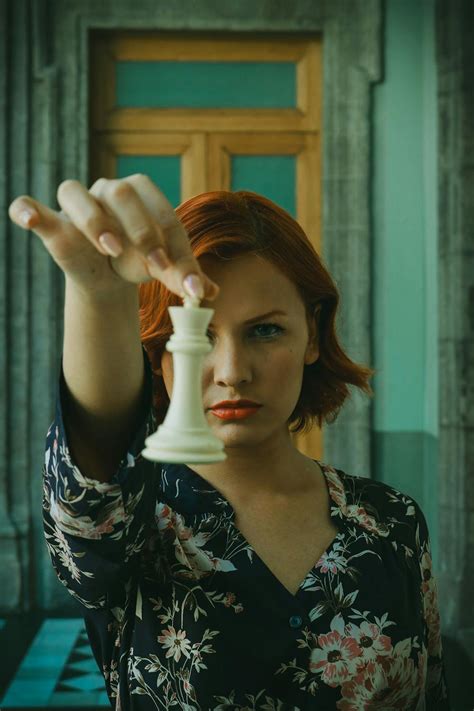 Redhead Woman Holding Out White Chess Piece In Front Of Her · Free