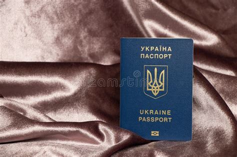 A Foreign Ukrainian Passport Stands On A Pink Crumpled Fabric A