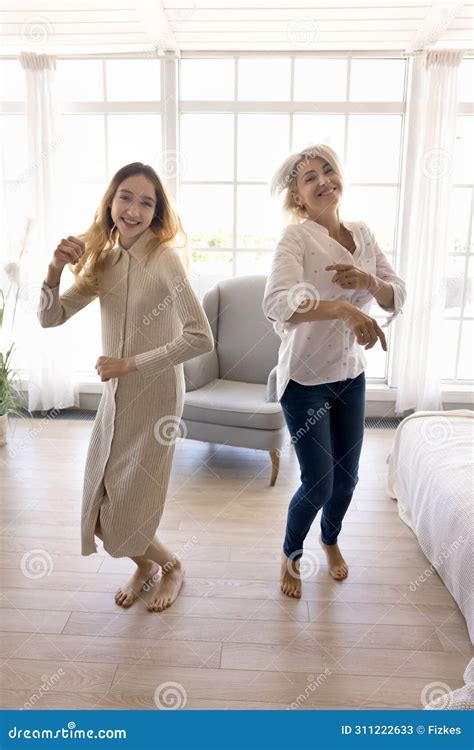 Mother And Preteen Daughter Looking At Camera And Dancing Stock Image