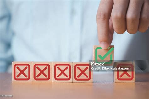 적십자 마크 중 녹색 올바른 기호 표시를 들고 있는 사업가는 사업 제안 개념을 승인하고 거부하기 위해 나무 큐브 블록에 화면을 인쇄합니다 알파벳 X에 대한 스톡 사진 및