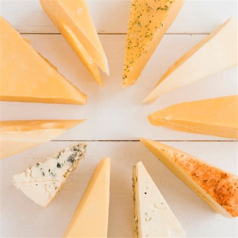 Free Photo Different Type Of Triangular Cheese Arranged In Circular On White Desk