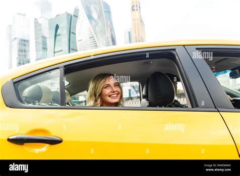 Photo Of Young Woman Sitting In Back Seat Of Yellow Taxi In Summer On