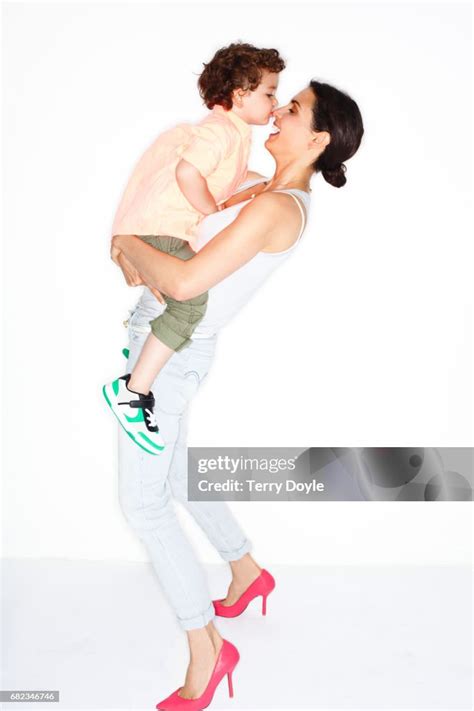 Mother Holding Son In Heels While He Give Her A Kiss High Res Stock