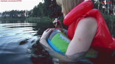 Alla Swims On An Inflatable Ring In The Lake And Pops It With A Stick And Wears A Red Inflatable