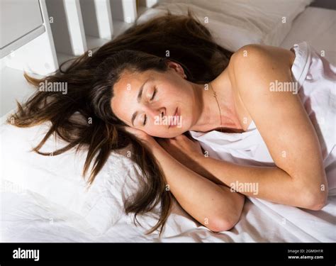 Portrait Of Relaxed Adult Woman Sleeping In Bed Alone In Home Stock