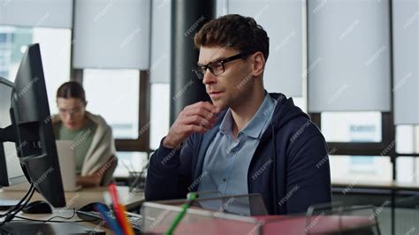 Premium Photo Thoughtful Programmer Looking Computer At Desk Focused Premium Photo Thoughtful Programmer Looking Computer At Desk Focused