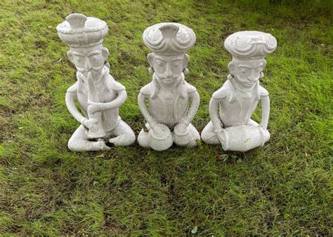 Three White Colored Human Shaped Idols Siting On Grass Stock Image