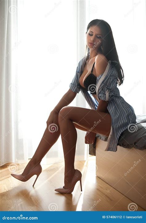 Beautiful Brunette Young Woman Wearing Black Lingerie Sitting On Bed