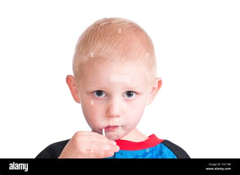 A Little Boy With A Sucker In His Mouth Seems Deep In Thought Stock
