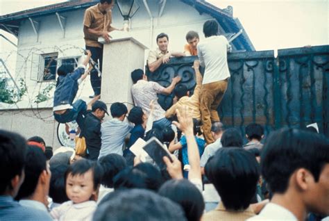 Desperate South Vietnamese Citizens Try To Climb The Walls Of The