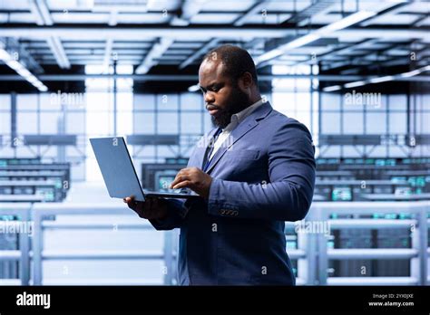 it staff member in server hub using laptop to monitor energy