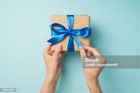 고립된 파스텔 블루 배경에 반짝이는 스팽글 위에 선명한 파란색 사틴 리본 리본 리본이 달린 수제 종이 기프트박스 1인칭 탑 뷰 사진 선물에 대한 스톡 사진 및 기타 이미지