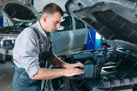 Premium Photo | Car mechanic using a computer laptop to diagnosing and checking up on car ...