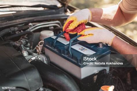 자동차 정비사는 자동차를 수리합니다 정비사가 상자에서 자동차 배터리를 꺼냅니다 자동차 배터리에 대한 스톡 사진 및 기타 이미지 자동차 배터리 변경 배터리 전원