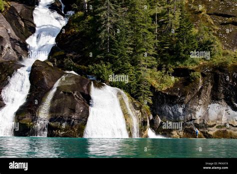 Stand Up Paddle Boarding In Front Of A Big Waterfall In The Glacially