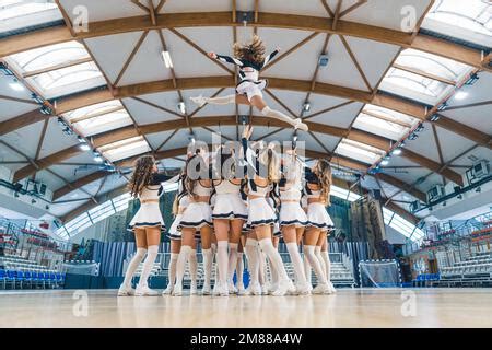 A Group Of Cheerleaders Are Captured In A Dynamic And Athletic Moment