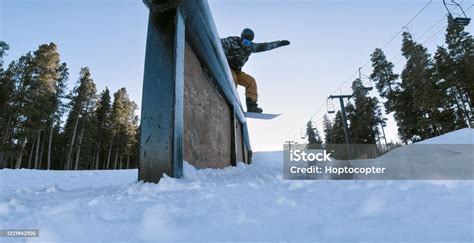 밝고 화창한 겨울 날에 콜로라도 볼더 근처 엘도라 스키 리조트에서 숲과 스키 점프와 전체 겨울 기어 승마 스턴트 레일의 스노우 보더 건강한 생활방식에 대한 스톡 사진 및