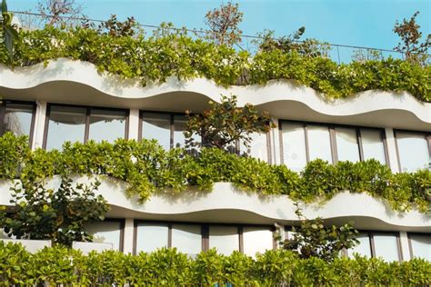 View Of Layered Eco Friendly Building Facade With Green Shrubs And