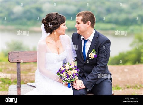 Attractive Bride And Groom Sitting On A Bench Stock Photo Alamy