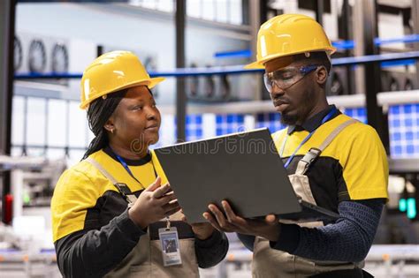 african american engineers supervise industrial automation system stock
