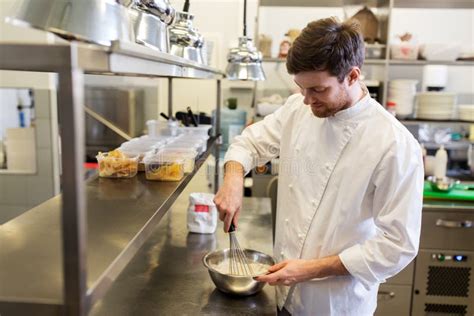 Cocinero De Sexo Masculino Feliz Que Cocina La Comida En La Cocina Del Restaurante Foto De