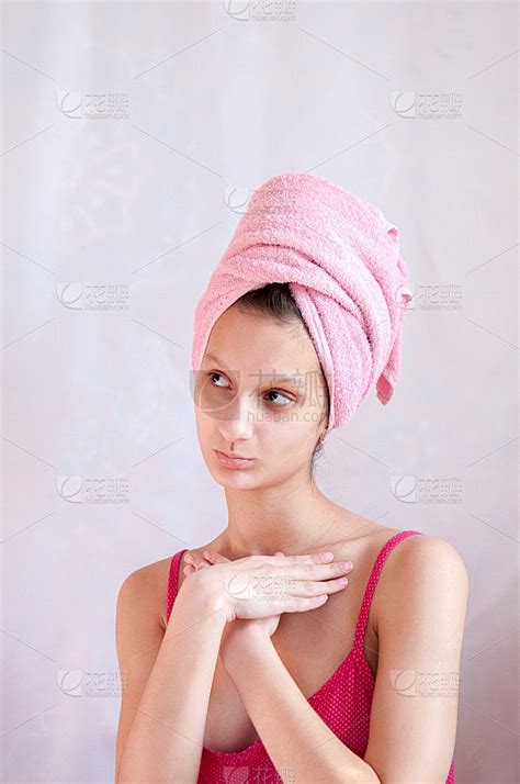 淡色背景上拿着粉色毛巾的女孩