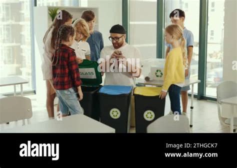Male Teacher Shows To The Pupils How And Where Sort Rubbish Correctly And Sorting The Rubbish On