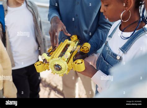 Close Up Of Young Black Girl Holding Robot Model During Engineering