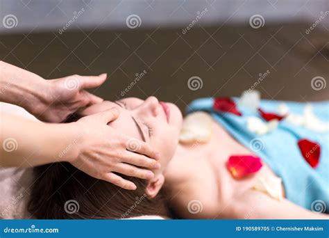 Young Beautiful Woman Receiving Head Face Massage In Beauty Spa With
