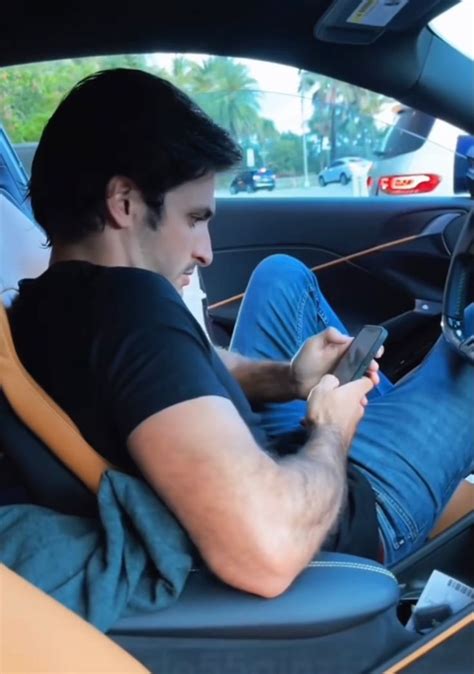 A Man Sitting In The Passenger Seat Of A Car Holding A Cell Phone And