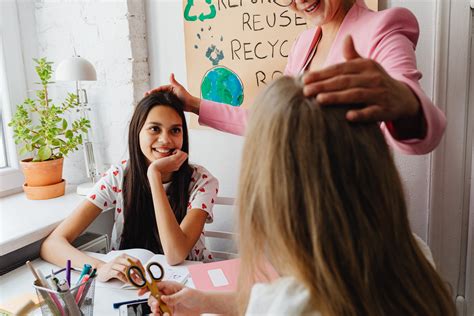 A Teacher Touching The Heads Of Her Young Students Photos By Canva