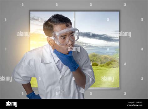 Asian Nerd Scientist Standing And Thinking Something With A Window