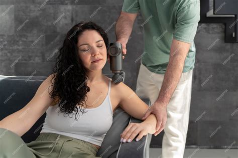 Free Photo High Angle Man Using Massage Gun On Woman