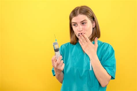 Free Photo Front View Female Doctor Holding Huge Injection On Yellow