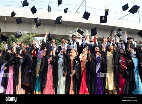 A Group Of Graduates Expressing Their Delight In Front Of The Sculpture