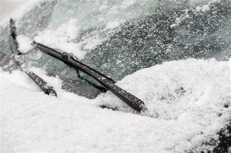 자동차 와이퍼 블레이드 자동차 창문에서 눈을 청소합니다 눈 조각이 두꺼운 층으로 차를 덮었다 작업 와이퍼와 깨끗한 앞 유리로