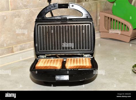 The Electric Grill Is Open Toasted Bread And Toast Lie On The Ribbed