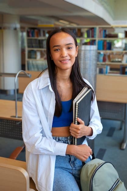 Étudiant Smiley Vue De Face Tenant Des Livres Photo Gratuite