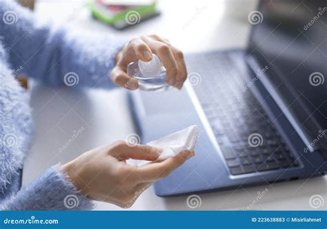 Woman Wiping Her Laptop Computer While Working From Home Stock Image