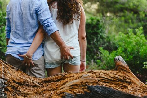 Couple In Love Seen From Behind Holding Each Other And Touching Their