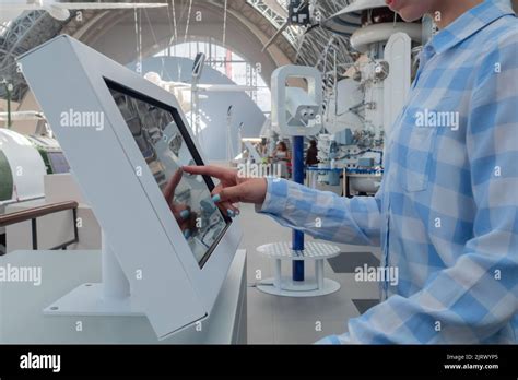 Woman Touching Interactive Touchscreen Display Kiosk At Exhibition